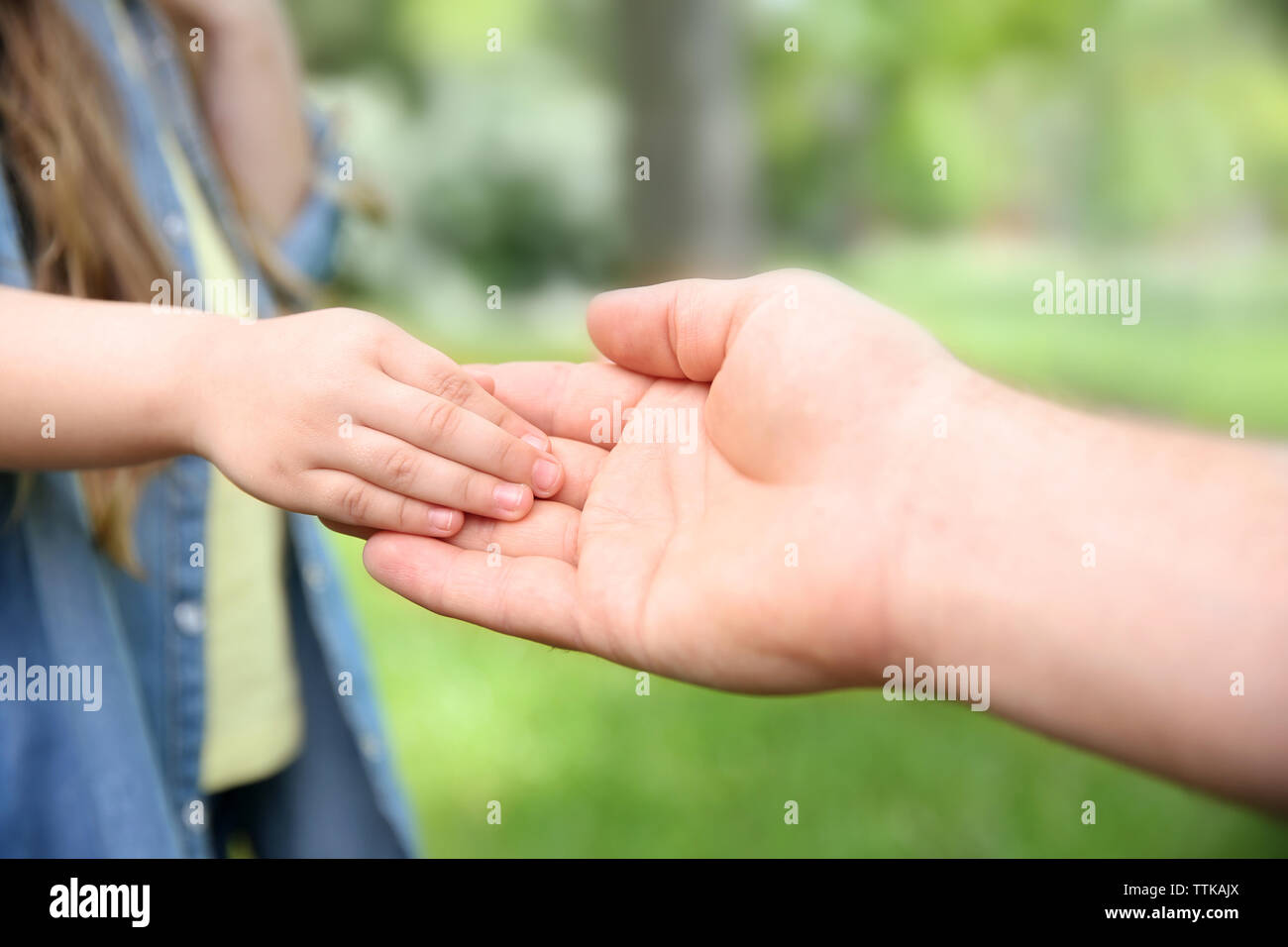 Adult and child hands on natural background Stock Photo - Alamy