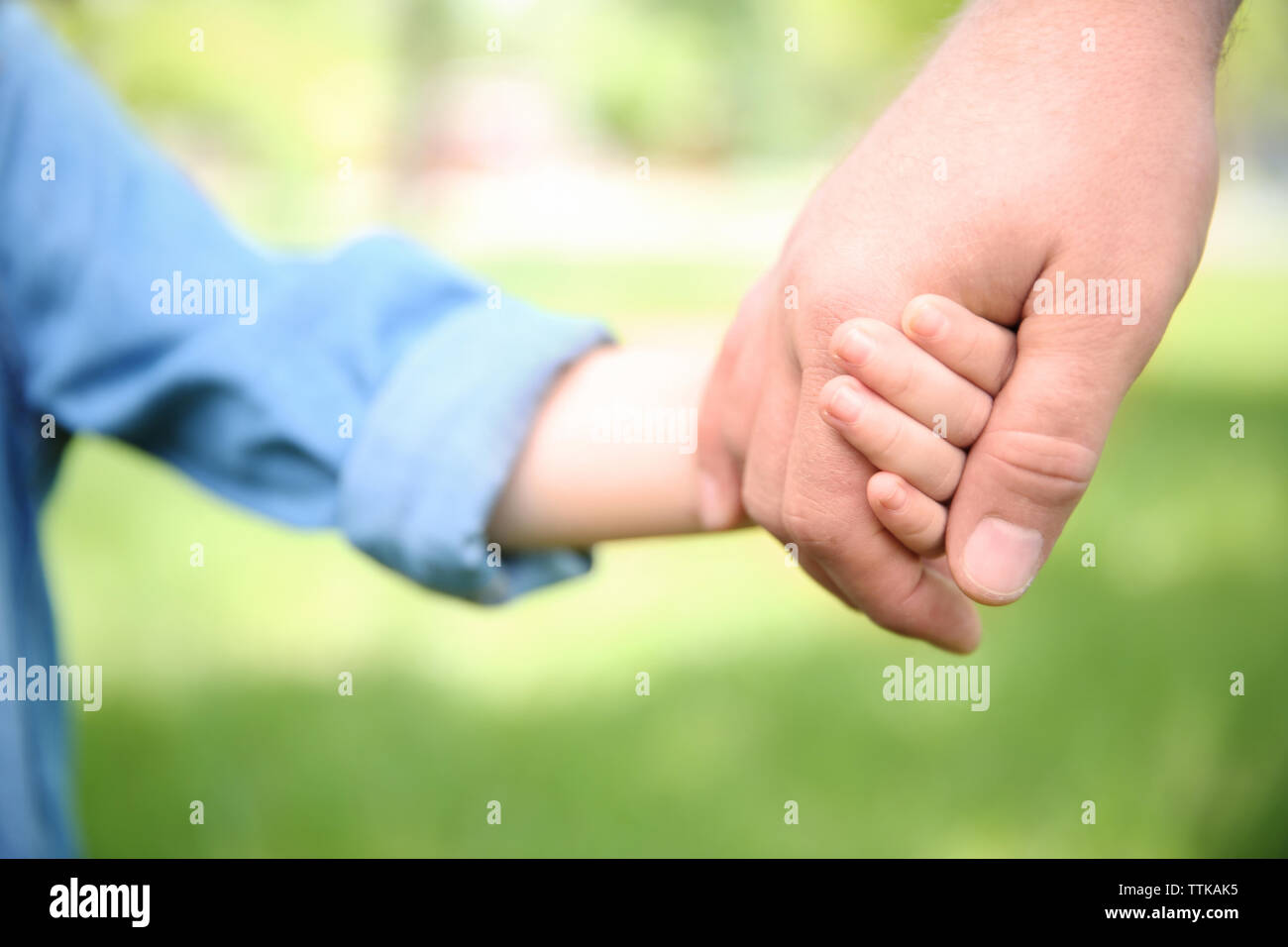 Adult and child hands on natural background Stock Photo - Alamy