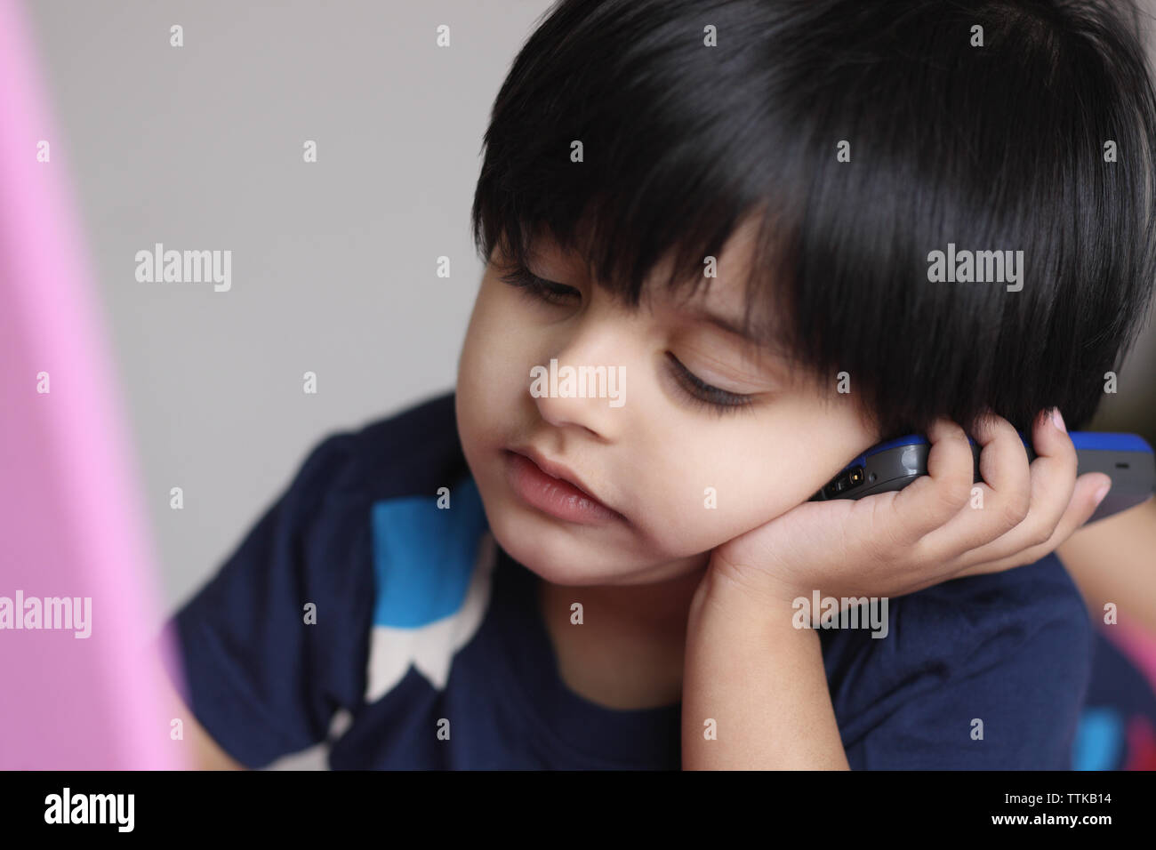 Girl using a mobile phone while working on a laptop Stock Photo - Alamy