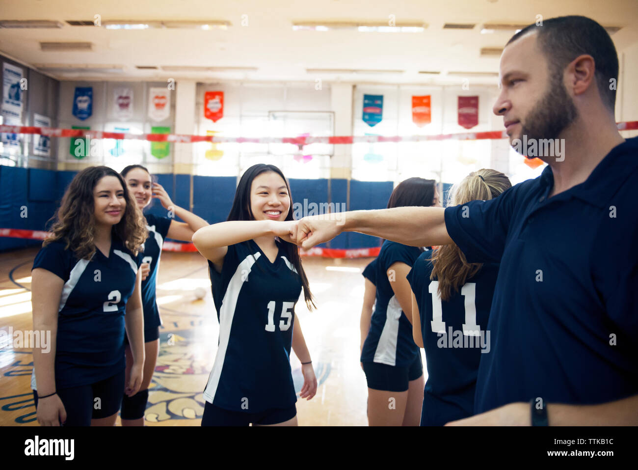 Player and coach fist bumping during practice Stock Photo - Alamy