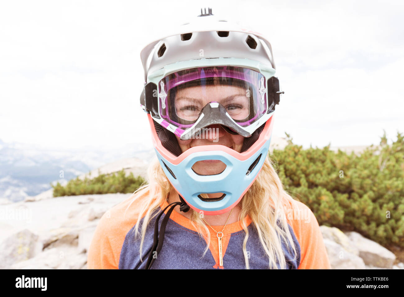 Close-up portrait of woman wearing helmet while standing on mountain ...