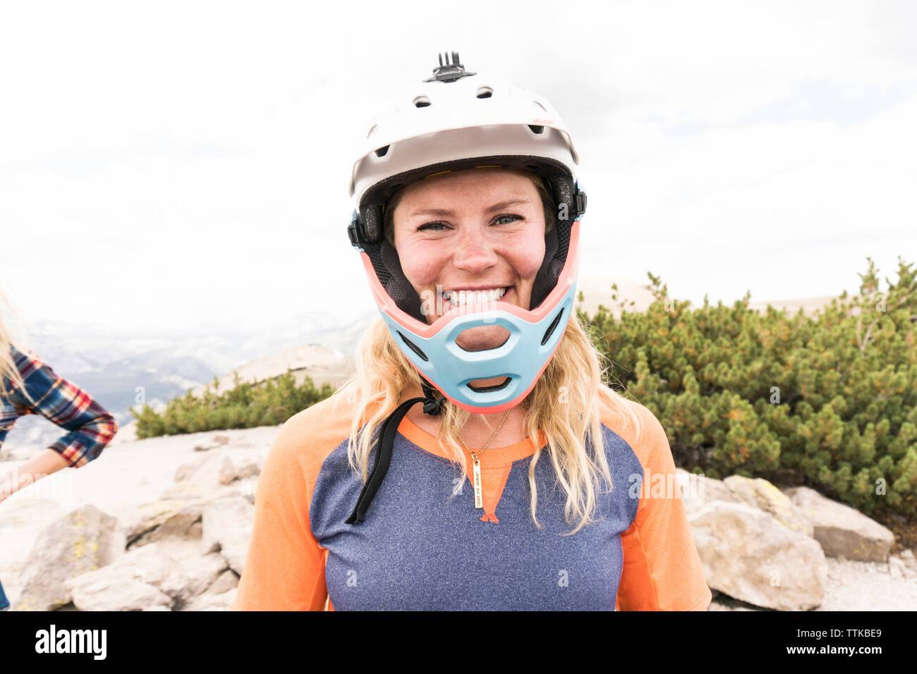 Close-up portrait of happy woman wearing helmet while standing on ...