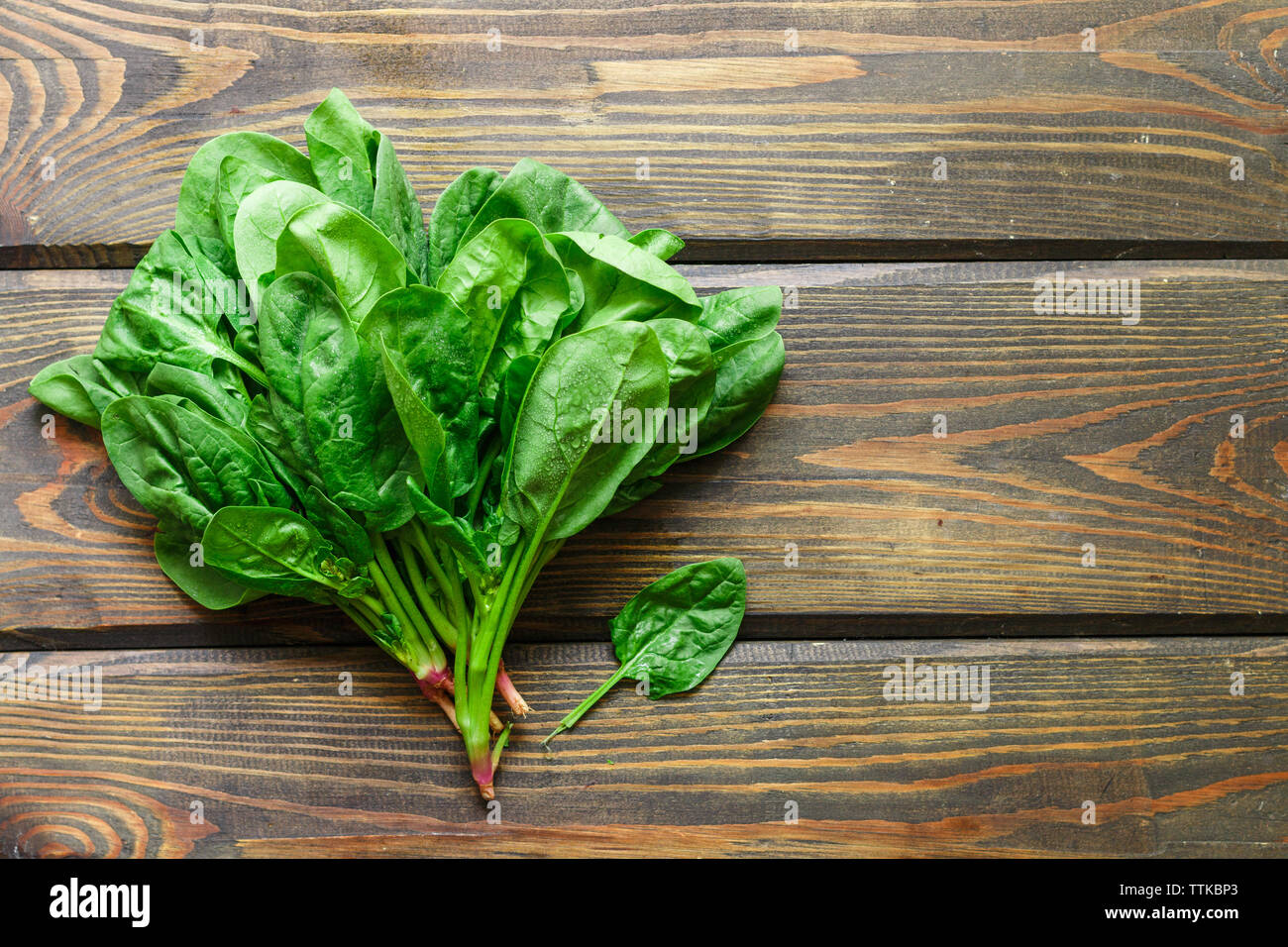 Fresh harvested organic spinach on a dark wooden table. Green ...