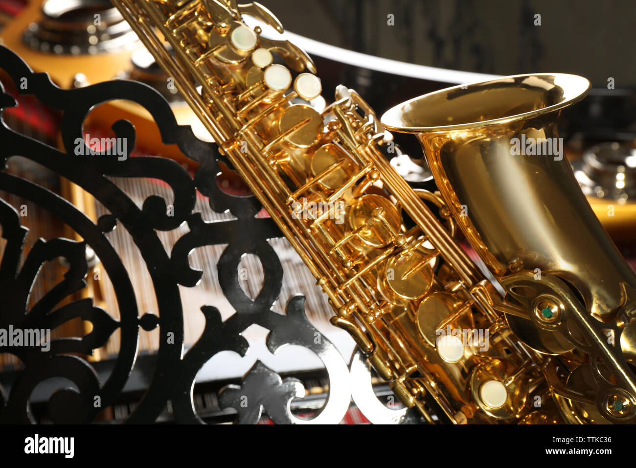 Saxophone lying on the piano, close up Stock Photo - Alamy