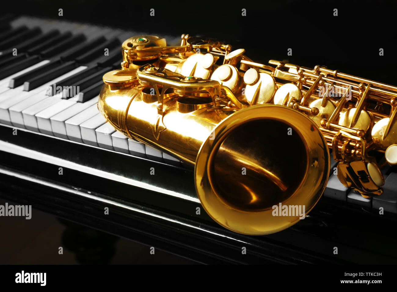 Saxophone lying on the piano, close up Stock Photo - Alamy