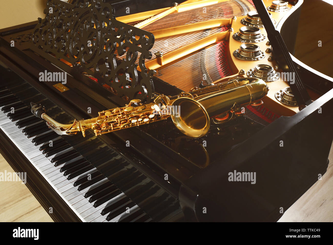 Saxophone lying on the piano, close up Stock Photo - Alamy