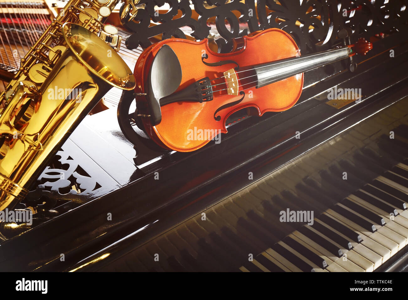 Violin and saxophone lying on piano, close up Stock Photo - Alamy