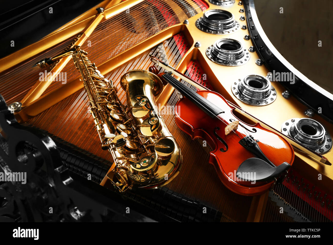 Violin and saxophone lying on piano, close up Stock Photo - Alamy