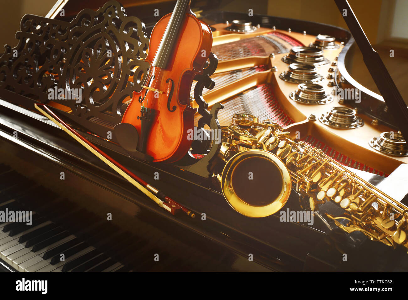 Violin and saxophone lying on piano, close up Stock Photo - Alamy
