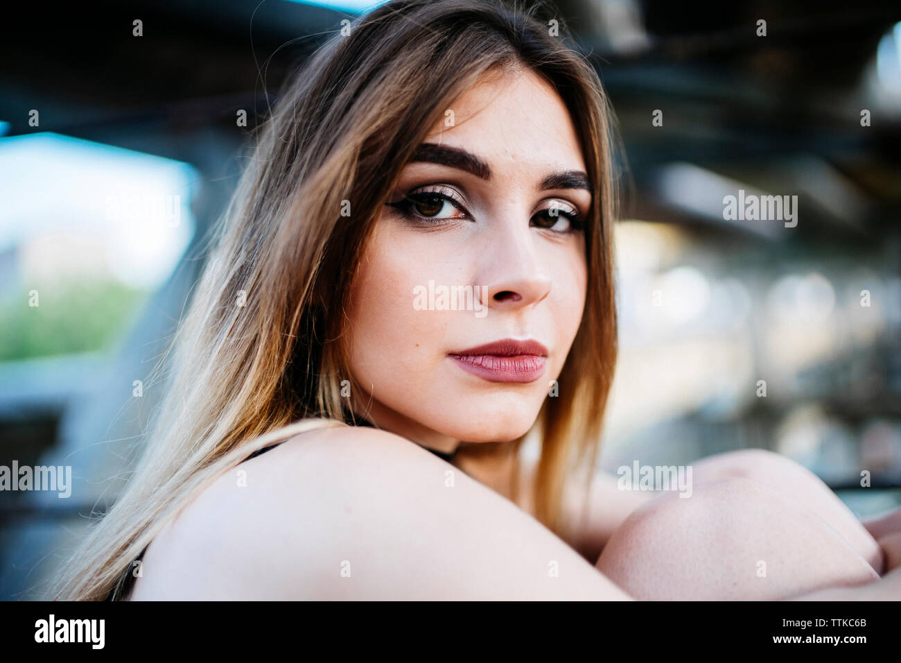 Side view portrait of confident young woman sitting in old factory ...