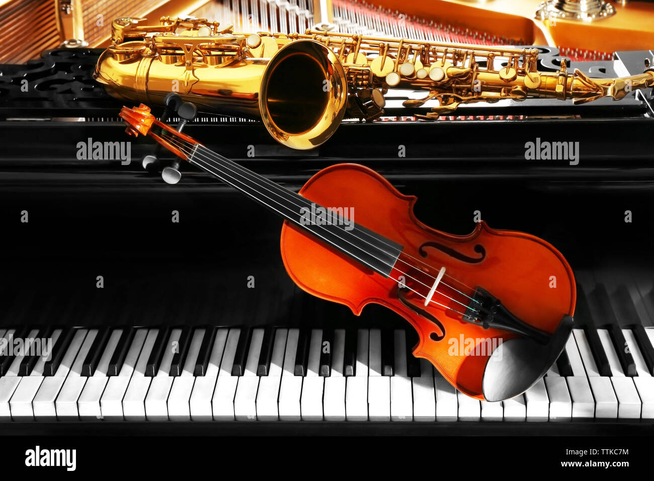 Violin and saxophone lying on piano, close up Stock Photo - Alamy
