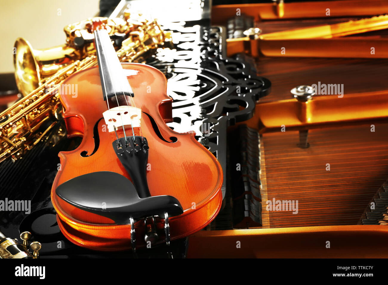 Violin and saxophone lying on piano, close up Stock Photo - Alamy