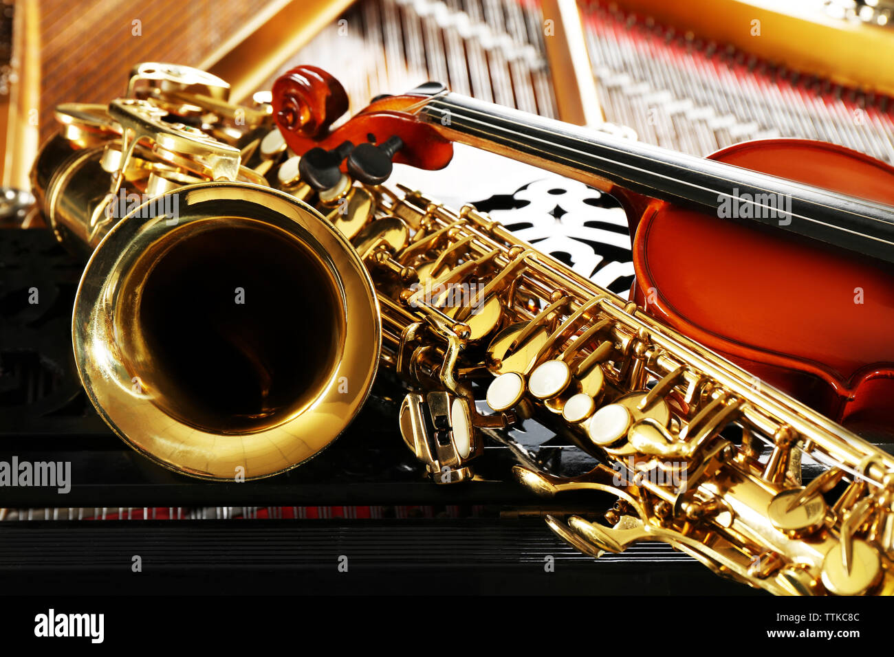 Violin and saxophone lying on piano, close up Stock Photo - Alamy