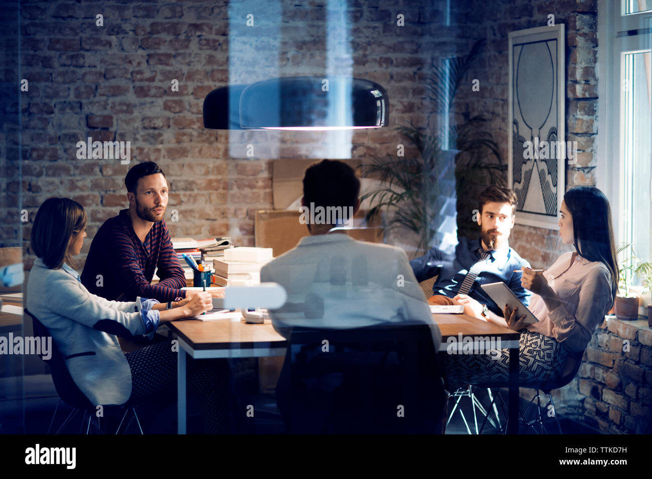 Colleagues having discussion at table in conference room Stock Photo ...