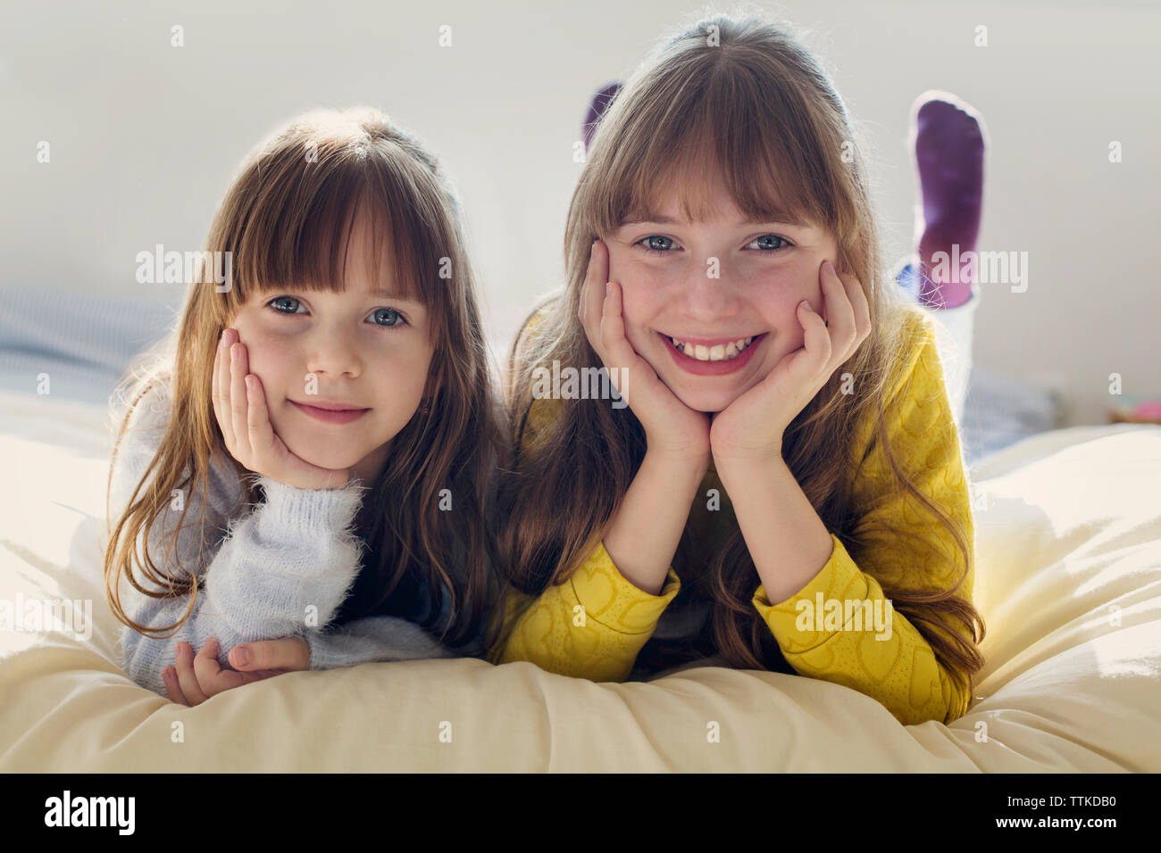 Portrait of happy siblings relaxing on bed at home Stock Photo - Alamy