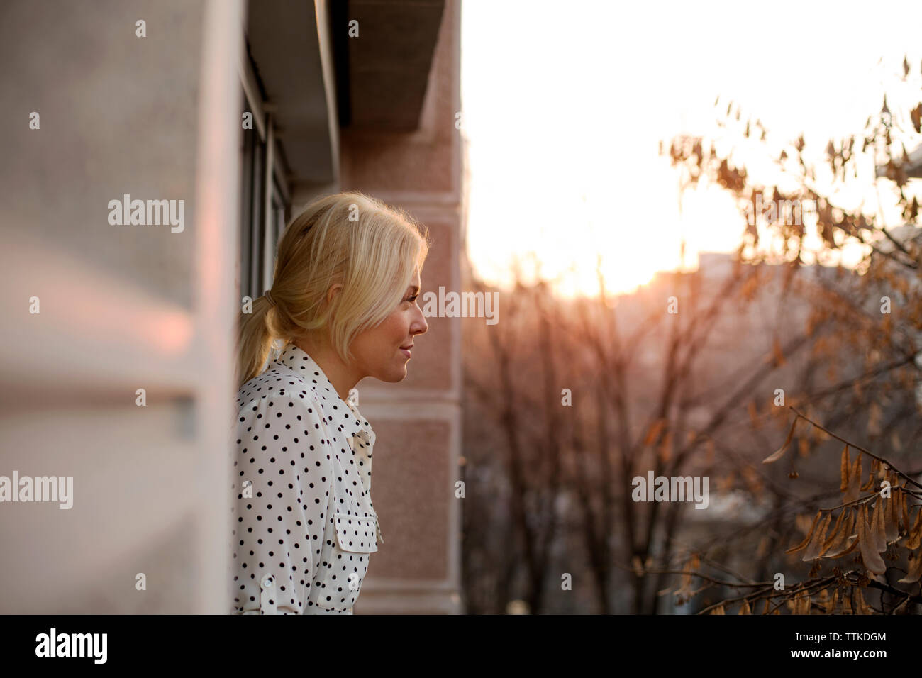 Side view of thoughtful woman looking through house window Stock Photo ...