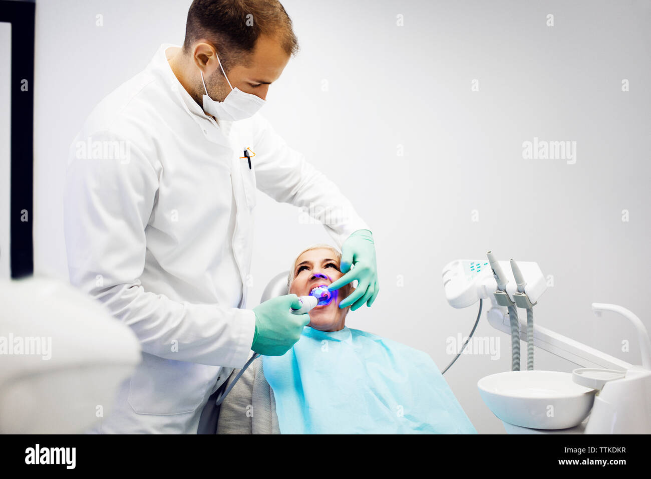 Dentist examining patient's teeth at clinic Stock Photo - Alamy