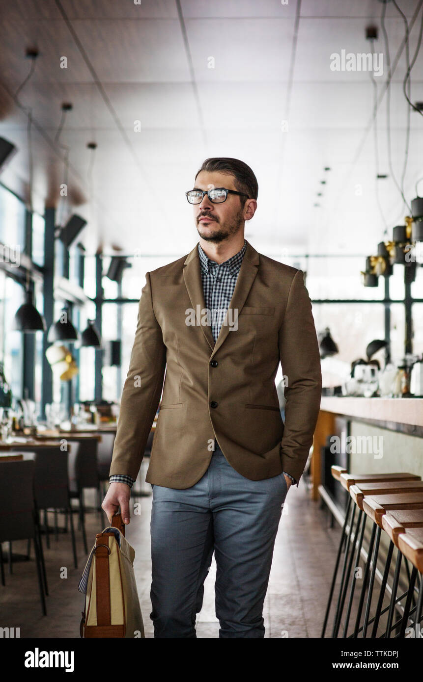 Confident businessman walking with briefcase in restaurant Stock Photo ... Confident businessman walking with briefcase in restaurant Stock Photo ...