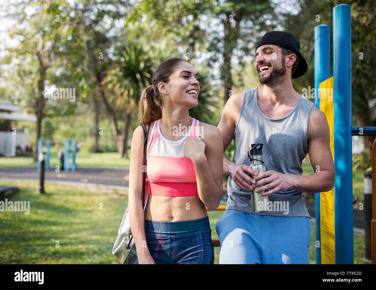 Front view of couple laughing while standing at park Stock Photo - Alamy