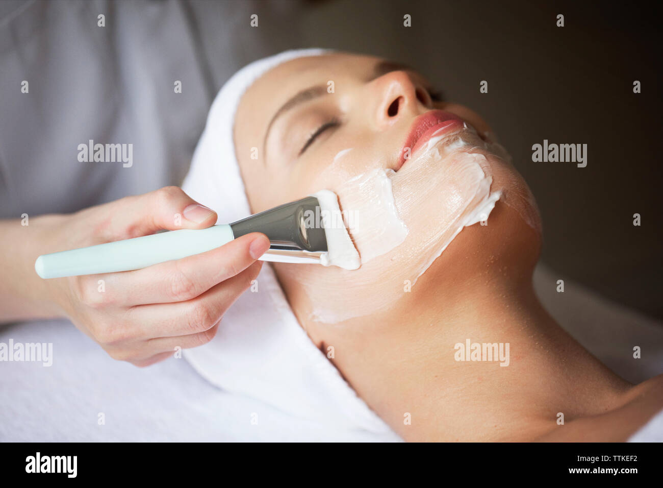 Female therapist applying facial mask on woman's face in spa Stock ...
