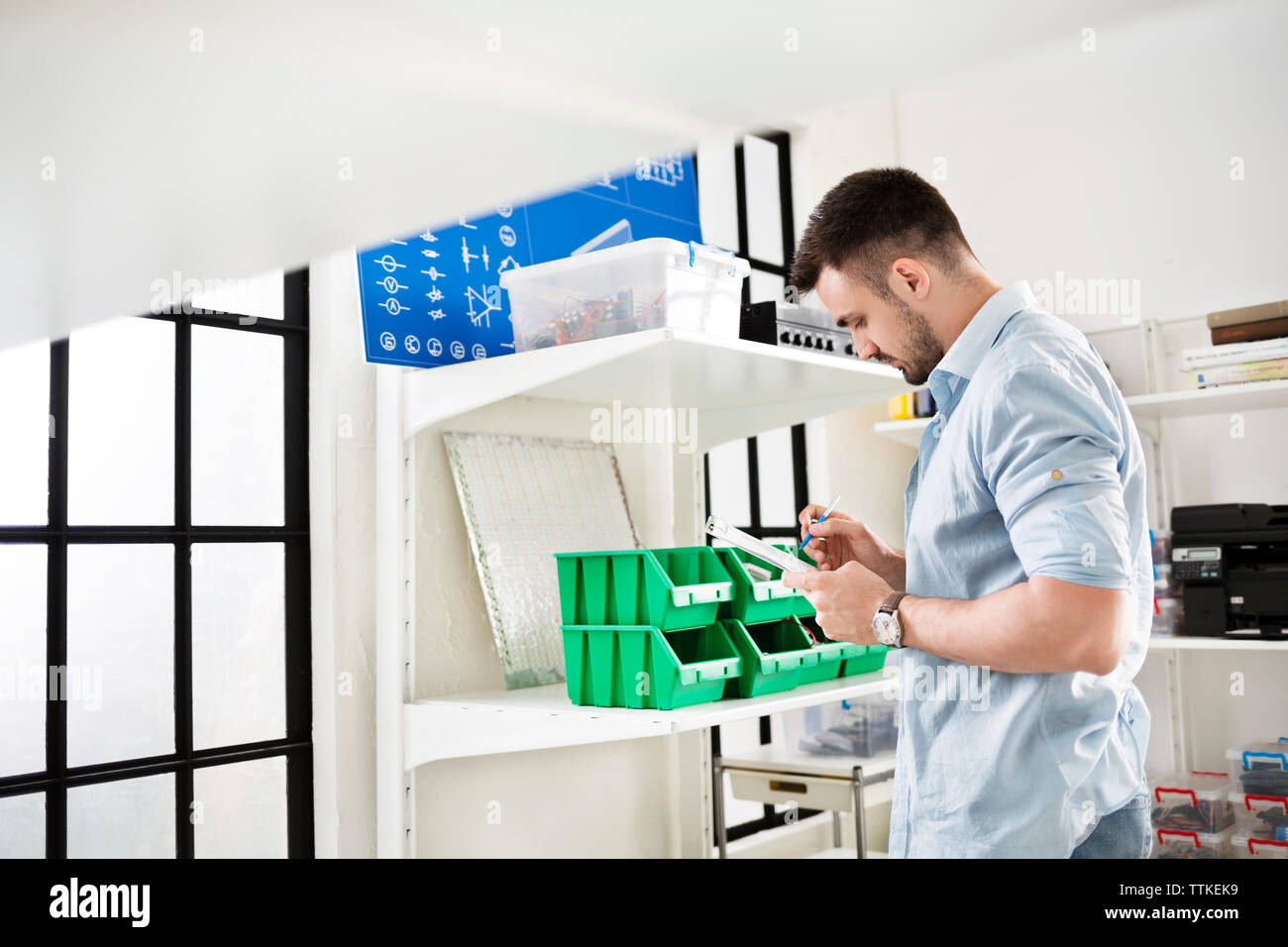 Engineer writing report while standing in electronic laboratory Stock ...