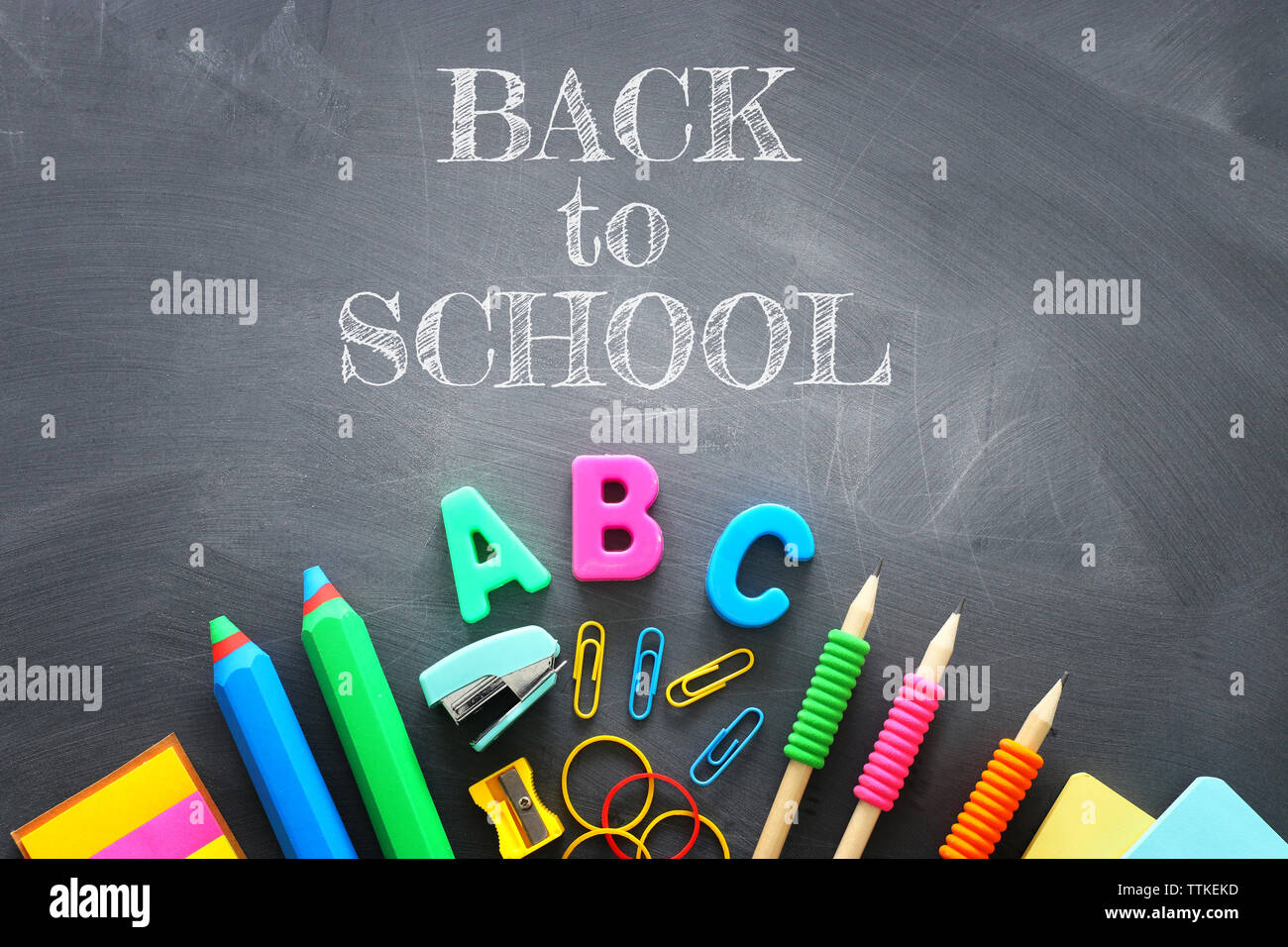 Back to school concept. stationery and books over classroom blackboard ...