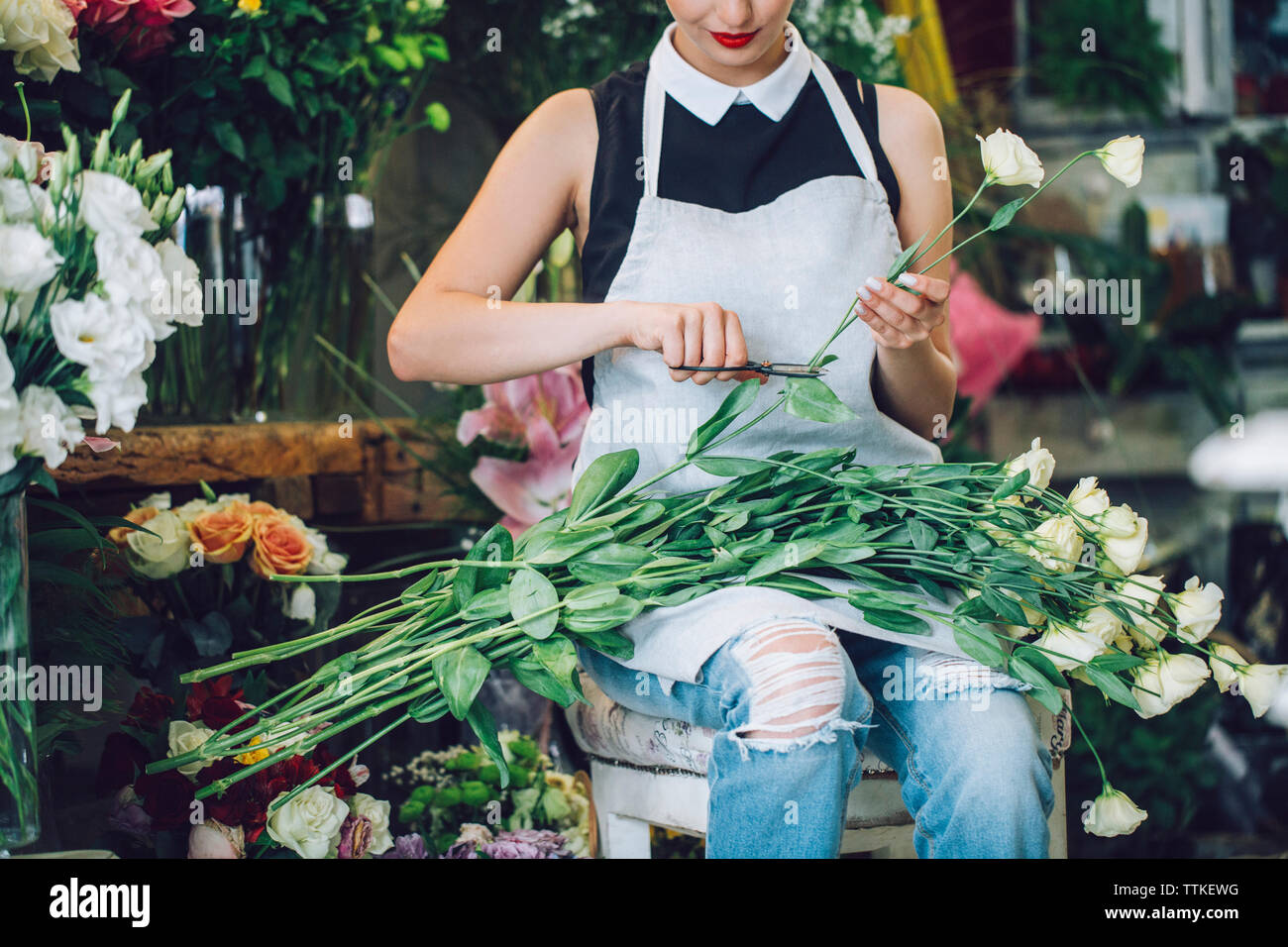 Midsection of florist cutting stems of roses at shop Stock Photo - Alamy