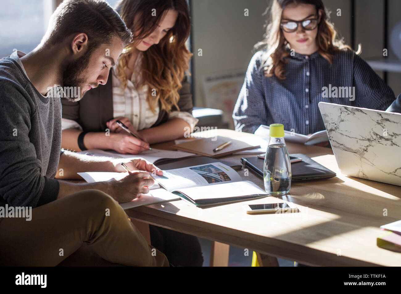 College students studying at table in classroom Stock Photo - Alamy