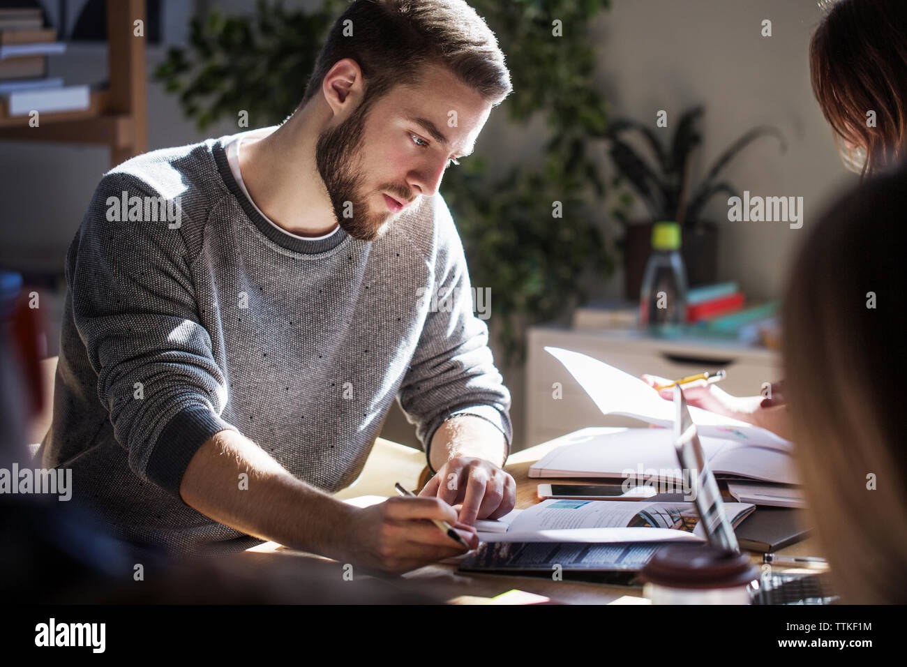 Man studying at table in classroom Stock Photo - Alamy