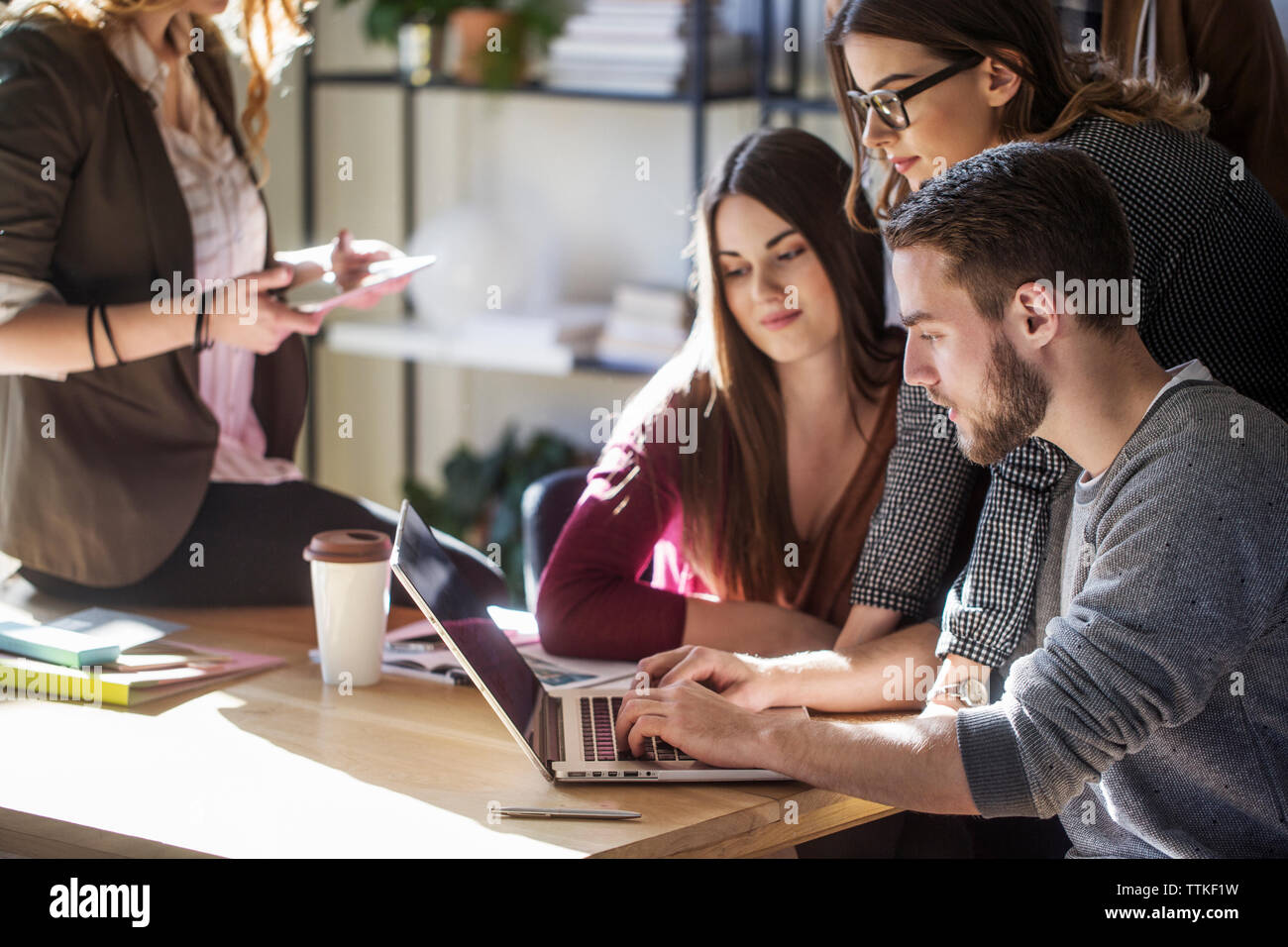 Students looking at laptop computer while studying in classroom Stock ...