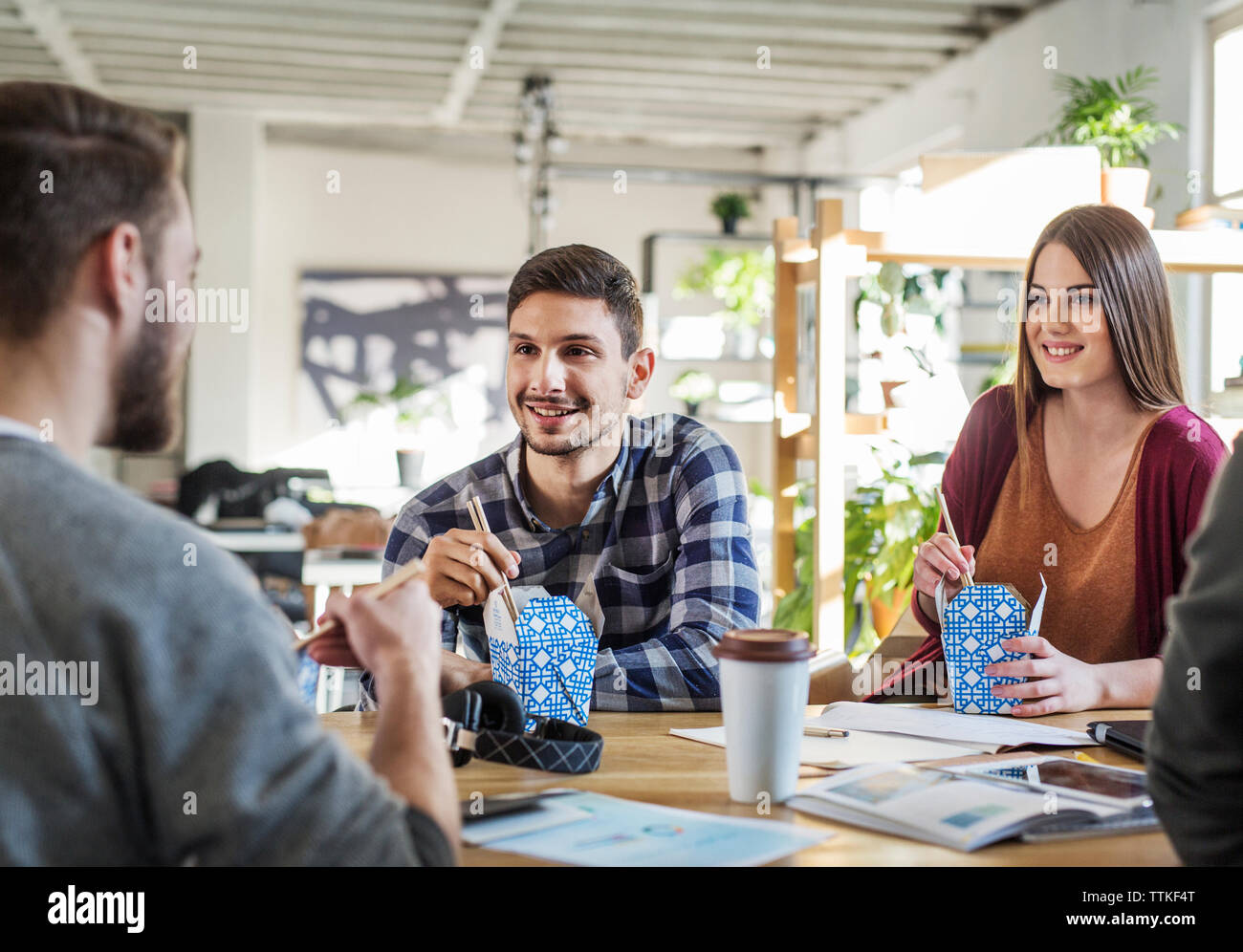 Friends having food while sitting at table in classroom Stock Photo - Alamy