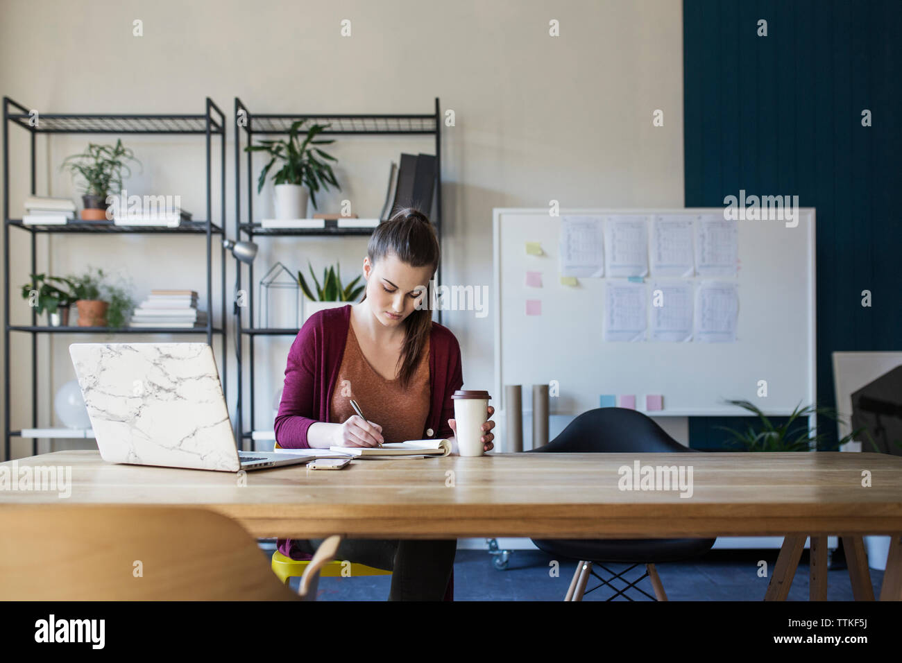 Woman studying while sitting at table in classroom Stock Photo - Alamy