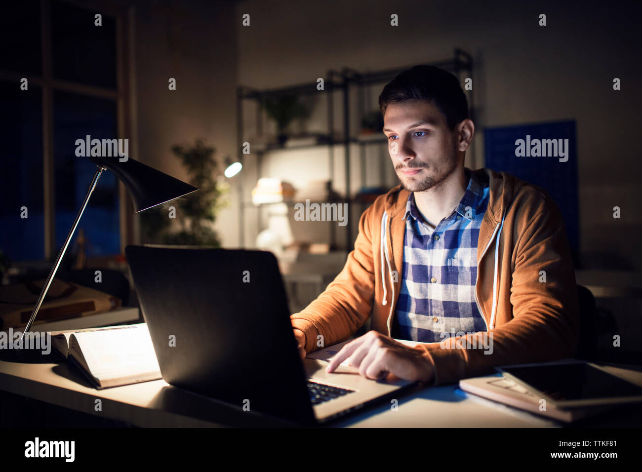 Confident student studying through laptop computer in library Stock ...