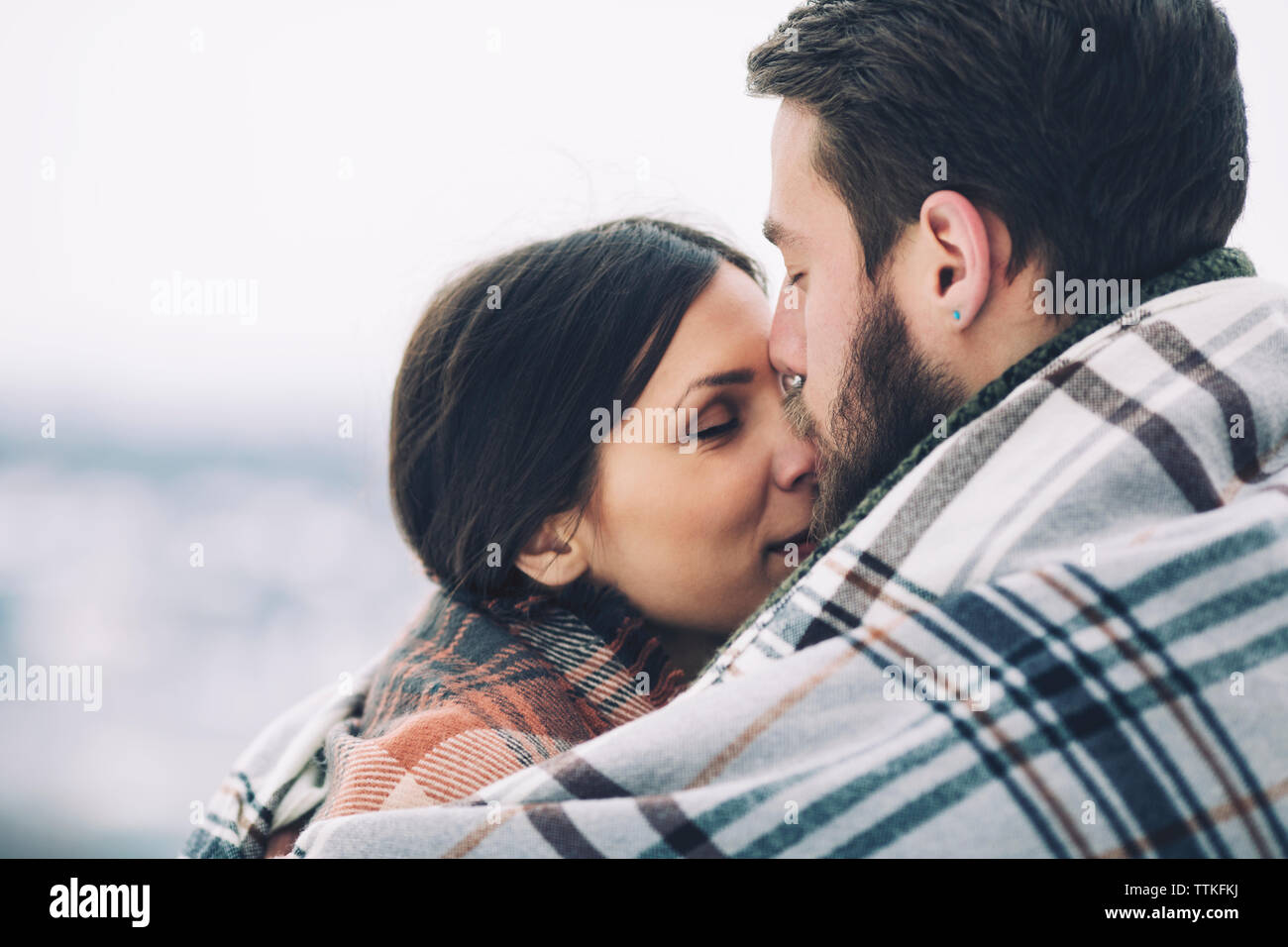 Close-up of romantic couple wrapped in scarf Stock Photo - Alamy