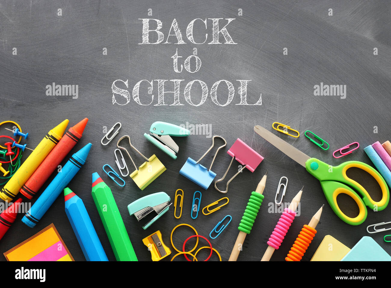 Back to school concept. stationery and books over classroom blackboard ...