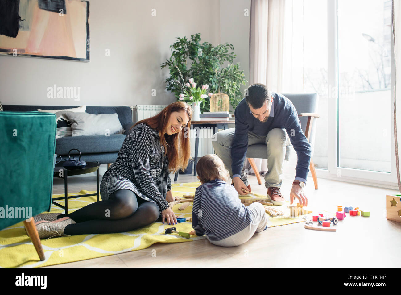 Parents and son playing with toys at home Stock Photo - Alamy