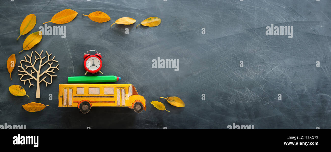 Back to school concept. Top view banner of school bus, alarm clock and ...