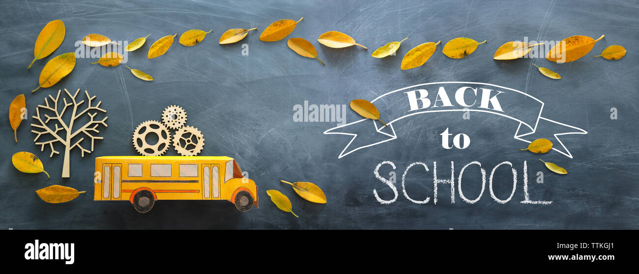 Back to school. Top view banner of cardboard school bus with wooden ...