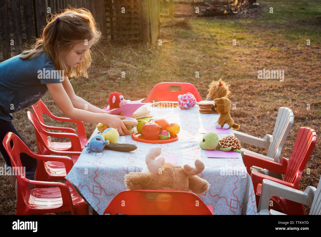 Side view of girl serving sandwich on table at yard Stock Photo - Alamy