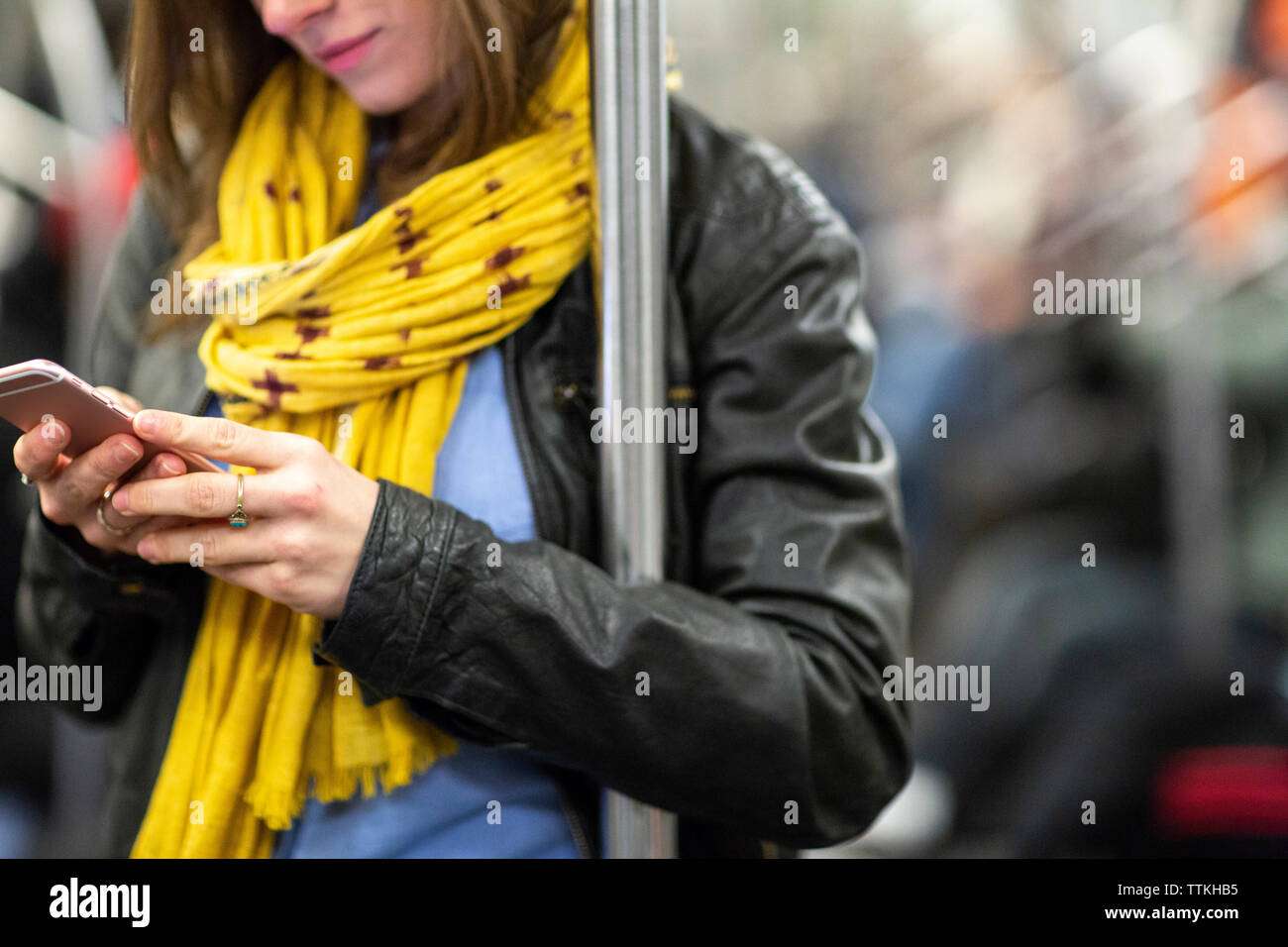 Midsection of woman using mobile phone while standing in train Stock ...