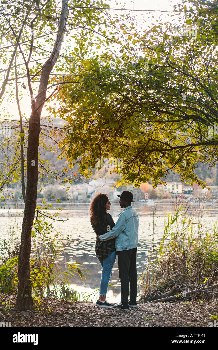 Side view of romantic couple standing at lakeshore Stock Photo - Alamy
