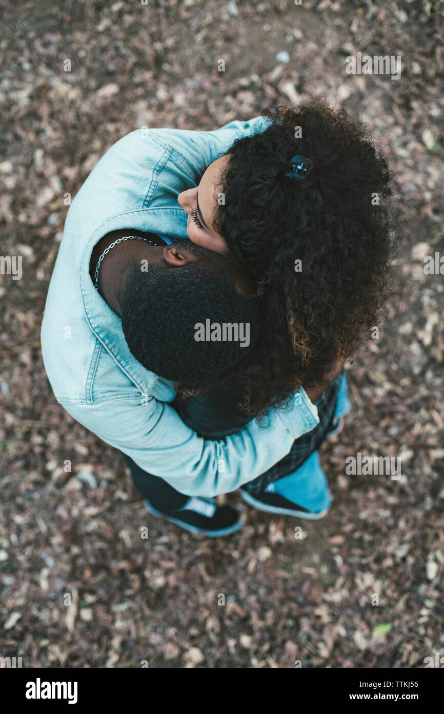 High angle view of romantic couple embracing while standing on field at ...