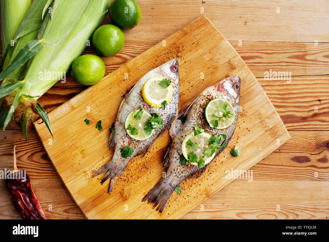 Overhead view of raw fish on cutting board Stock Photo - Alamy