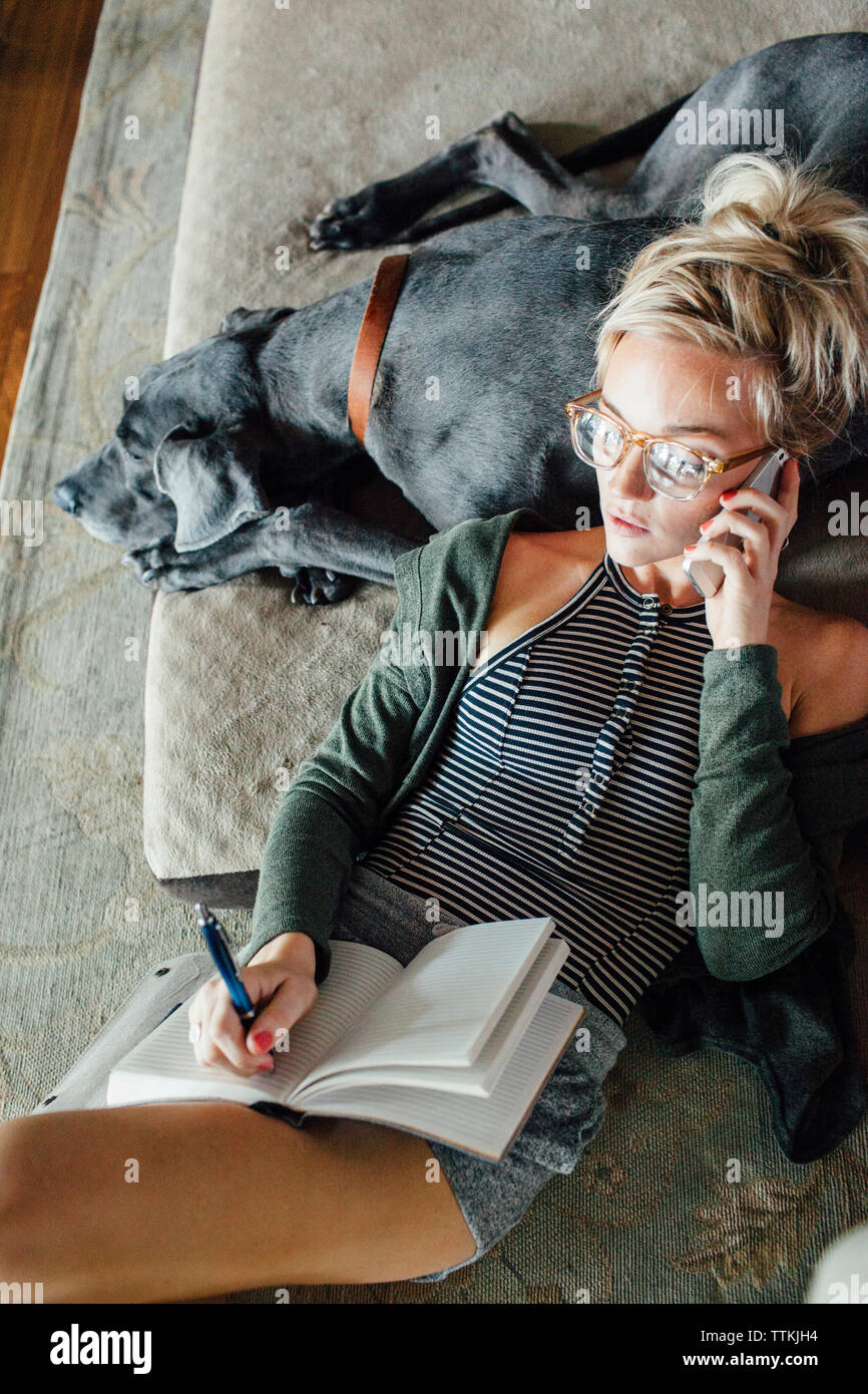 Overhead view of woman talking with diary using smart phone while ...