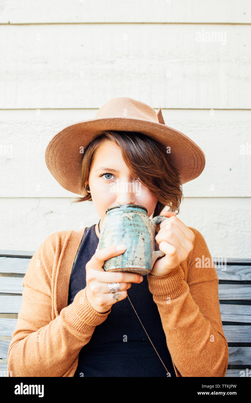 Close-up portrait of woman having drink while sitting on bench Stock ...