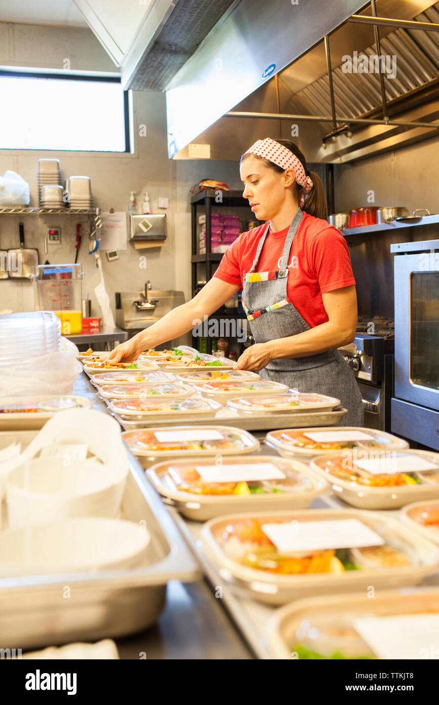 Female chef packing food on kitchen counter in restaurant Stock Photo ...