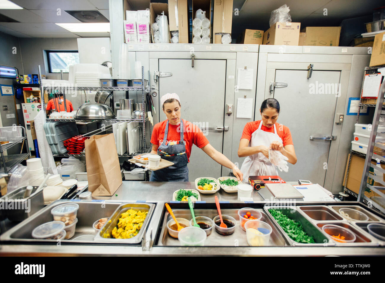 Female coworkers working in commercial kitchen Stock Photo - Alamy
