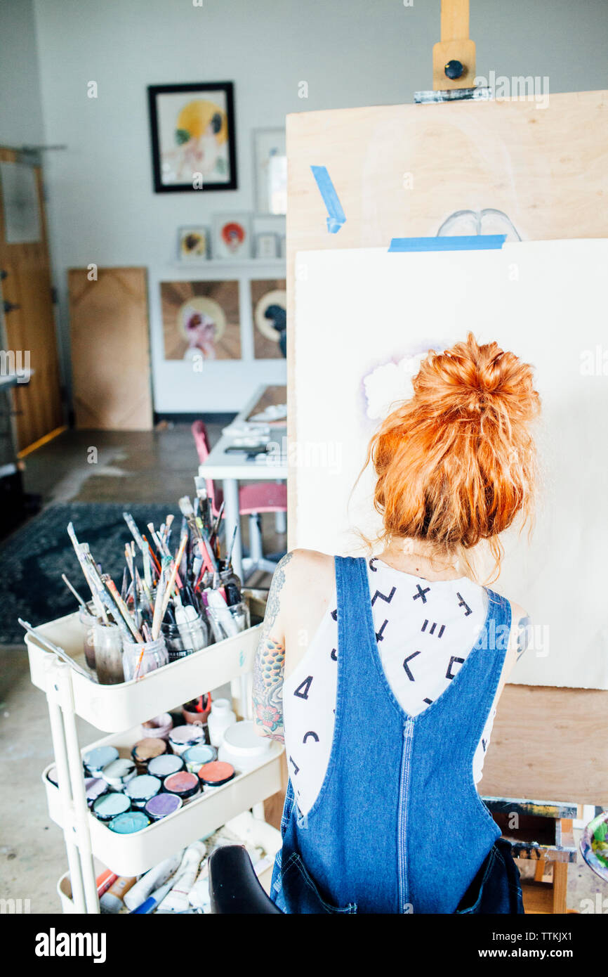 Rear view of artist drawing sketch on canvas in studio Stock Photo - Alamy