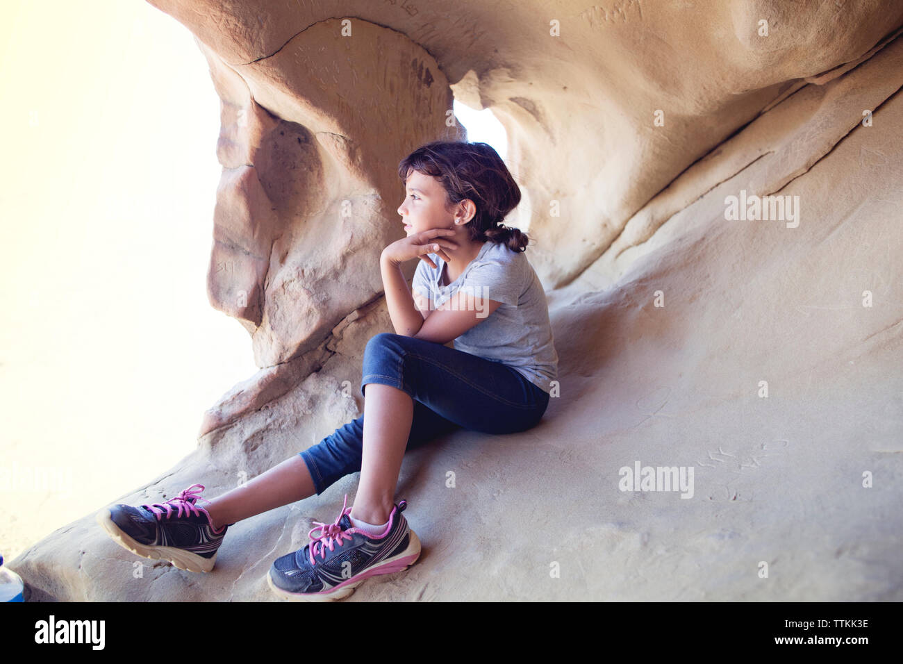 Thoughtful girl sitting in cave Stock Photo - Alamy