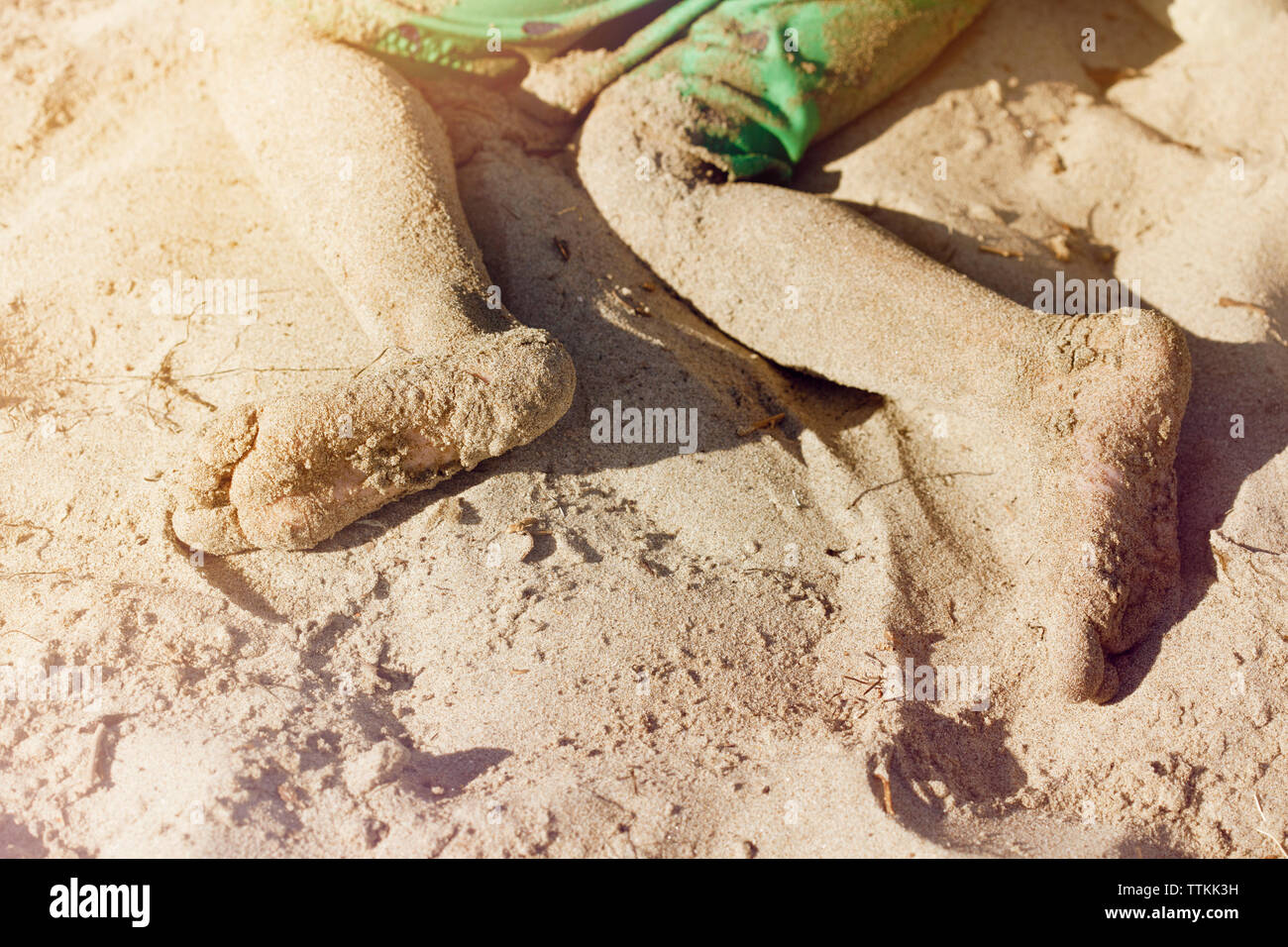 Messy legs on boy lying on sand at beach Stock Photo - Alamy
